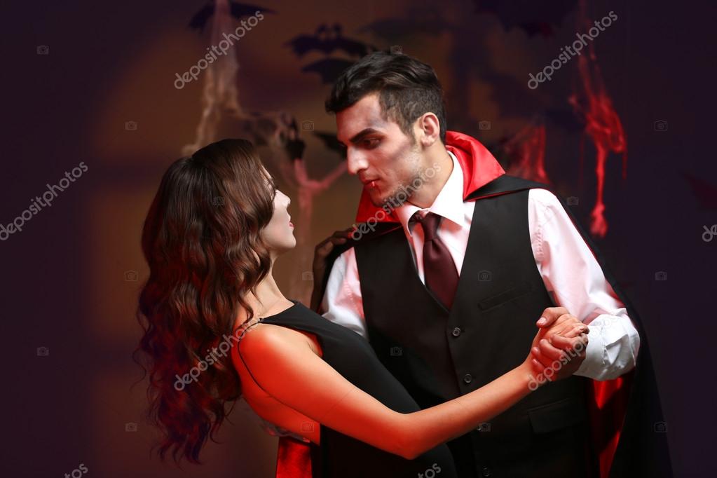 Young people dressed as vampires for Halloween party, on dark ...