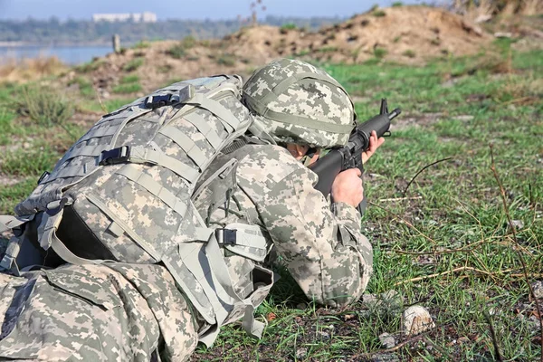 Soldier in camouflage taking aim at military firing range, close up ...
