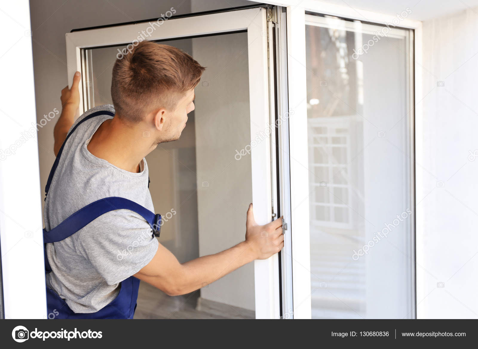 Worker installing window Stock Photo by ©belchonock 130680836
