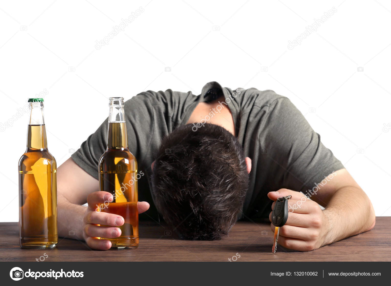 Young drunk man with car key and two bottles of beer on grey background ...
