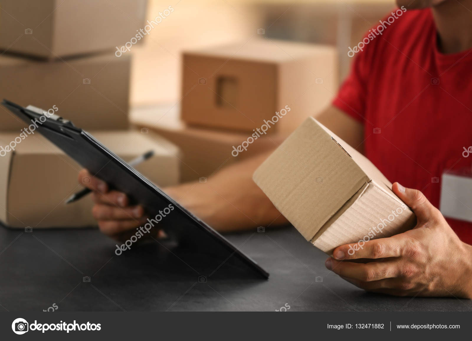 Courier holding carton box — Stock Photo © belchonock #132471882