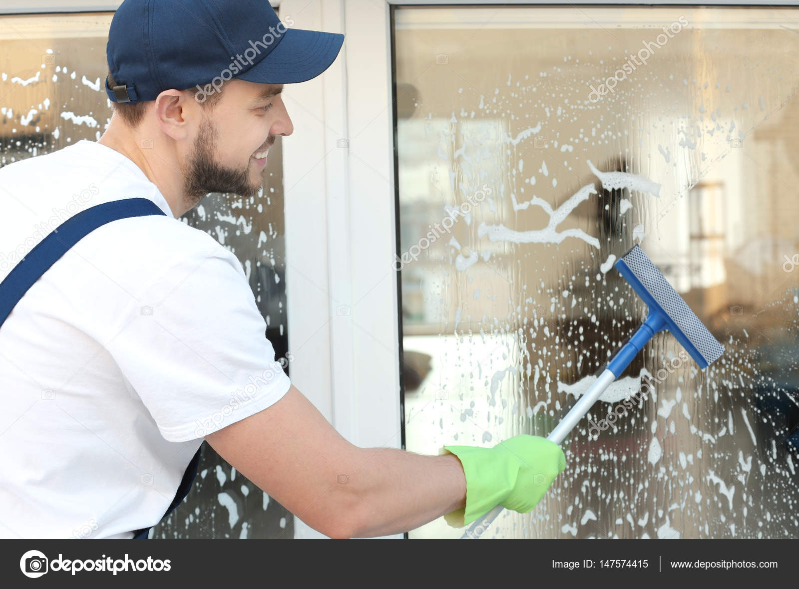 Young man washing window Stock Photo by ©belchonock 147574415