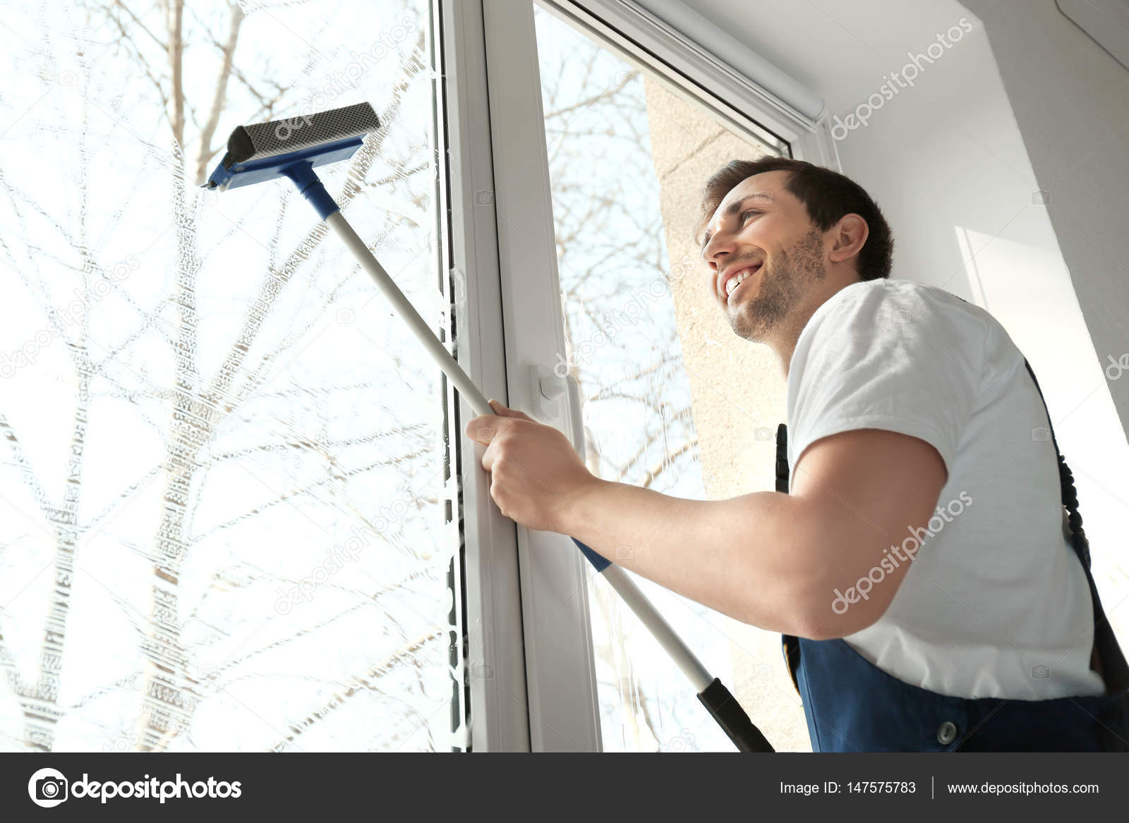 Young man washing window — Stock Photo © belchonock #147575783
