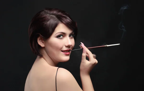 Woman smoking with cigarette holder Stock Photo by ©belchonock 148525121