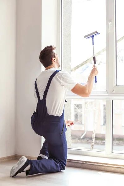 Young man washing window — Stock Photo © belchonock #147575783