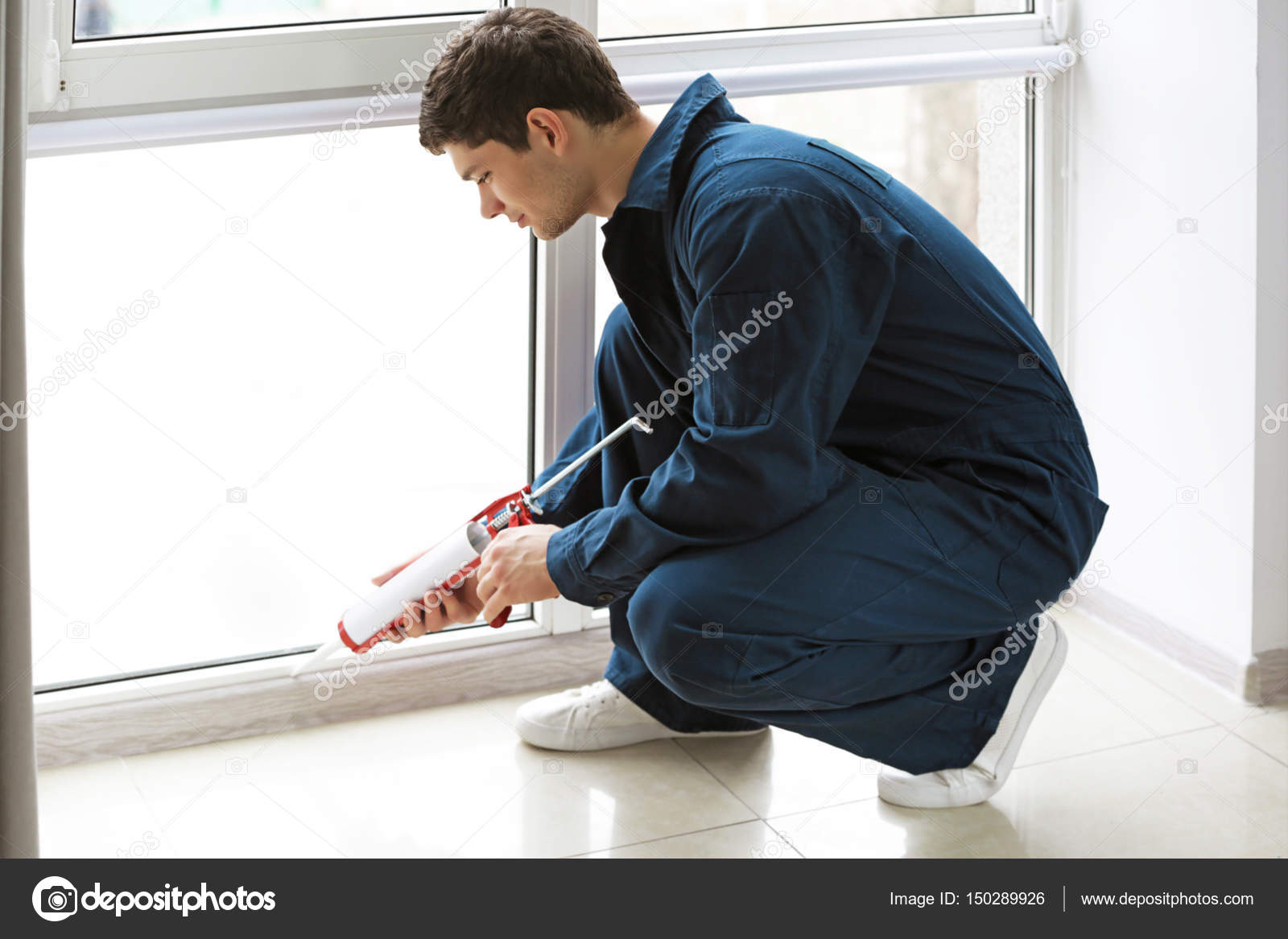 Worker sealing joints of office window — Stock Photo © belchonock ...