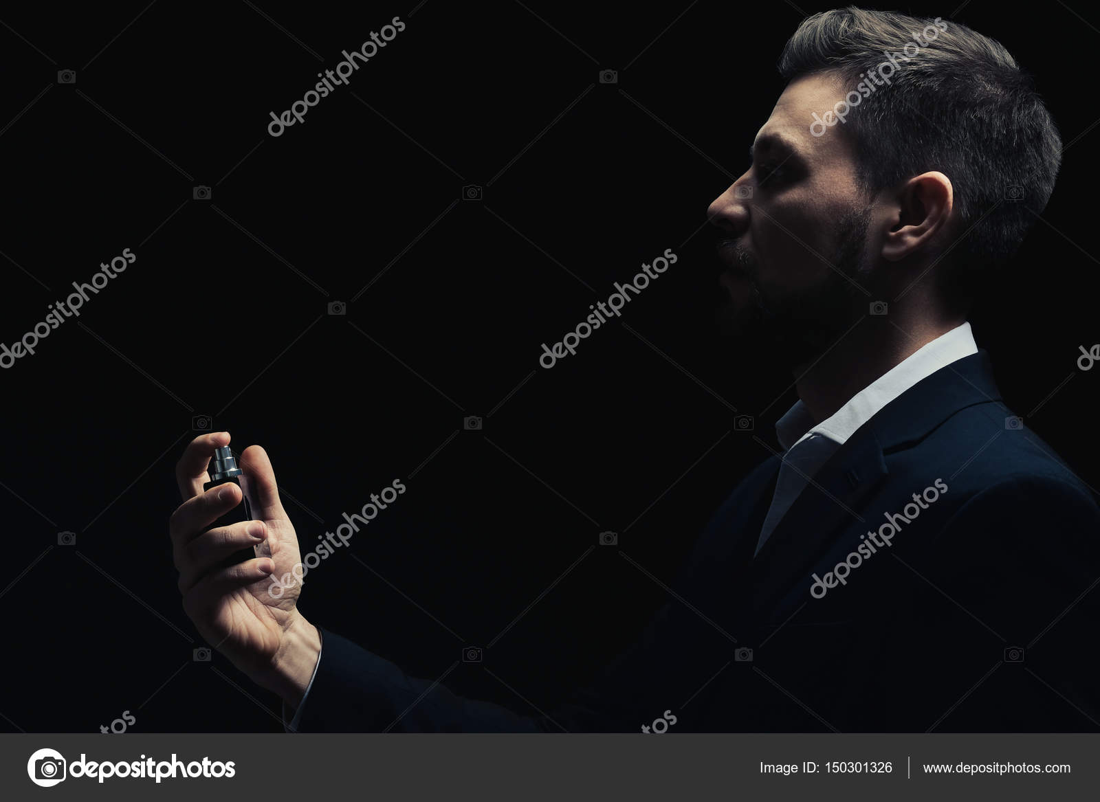 Handsome young man using perfume Stock Photo by ©belchonock 150301326