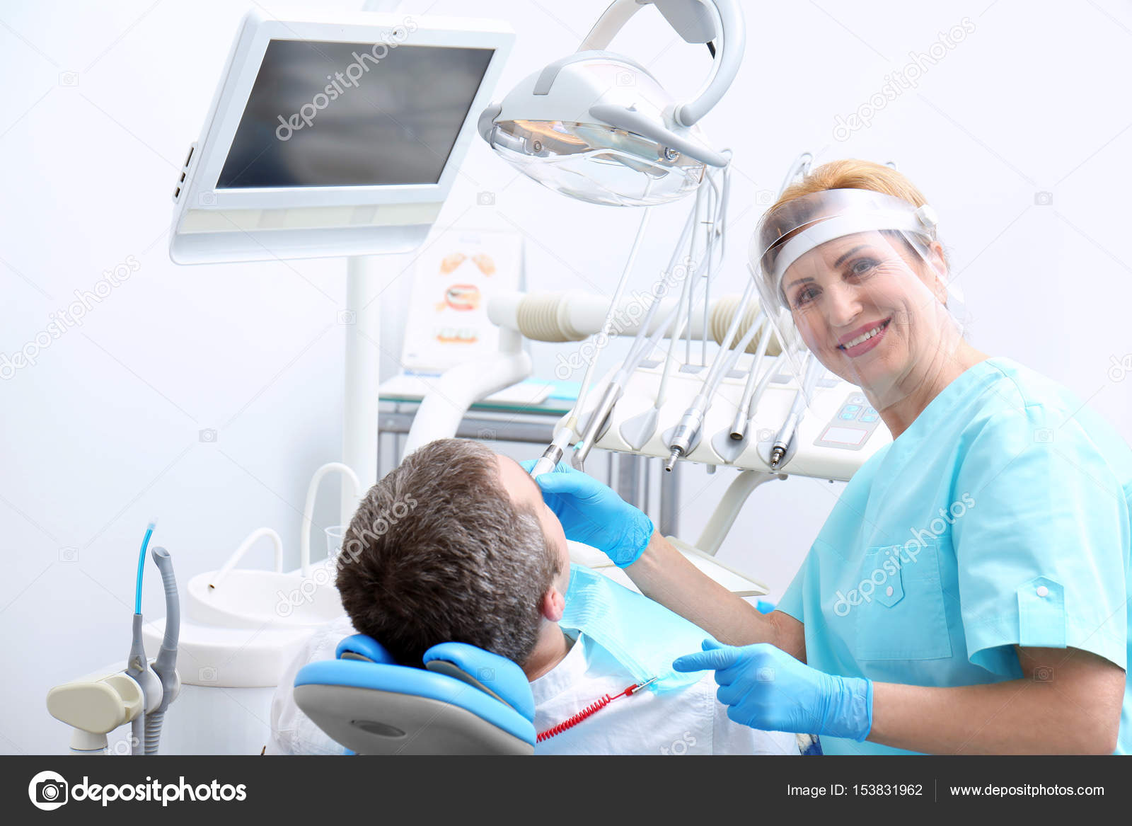 Dentist examining patient's teeth in clinic Stock Photo by ©belchonock ...