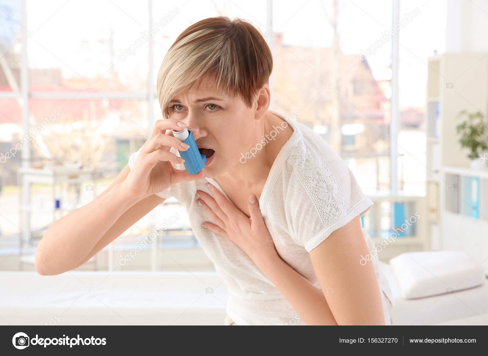 Adult woman using inhaler in clinic — Stock Photo © belchonock #156327270