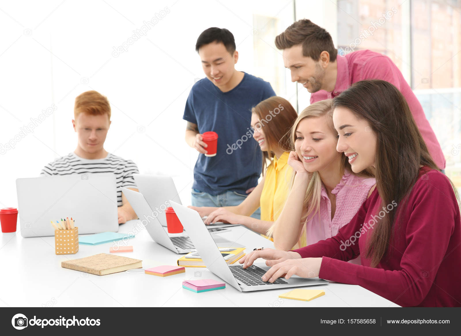 Young people working with laptops in office — Stock Photo © belchonock ...