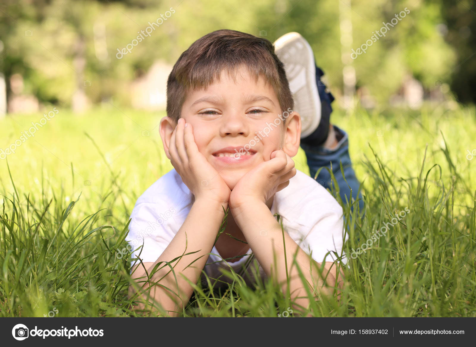 Boy lying on grass Stock Photo by ©belchonock 158937402