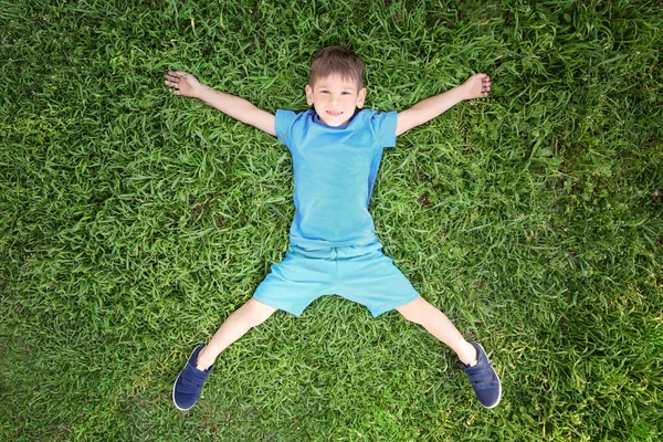 Cute little boy lying on grass Stock Photo by ©belchonock 159446806
