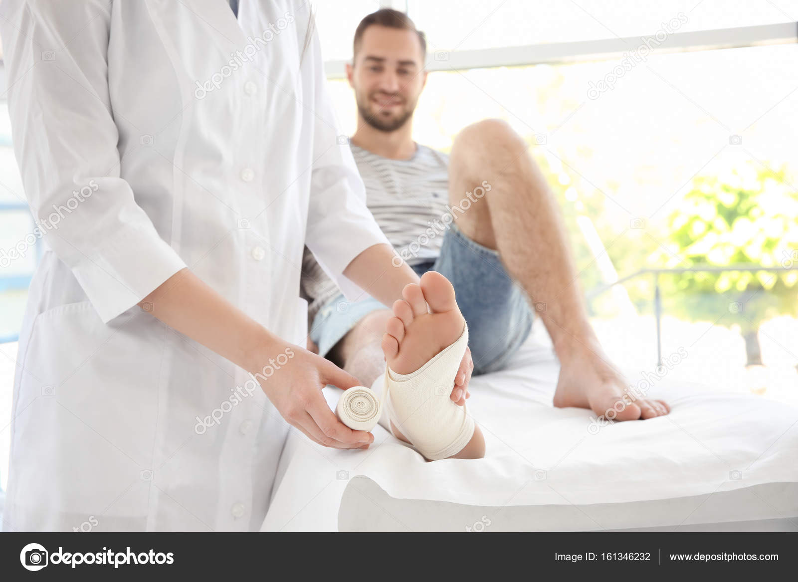 Doctor applying bandage onto leg Stock Photo by ©belchonock 161346232