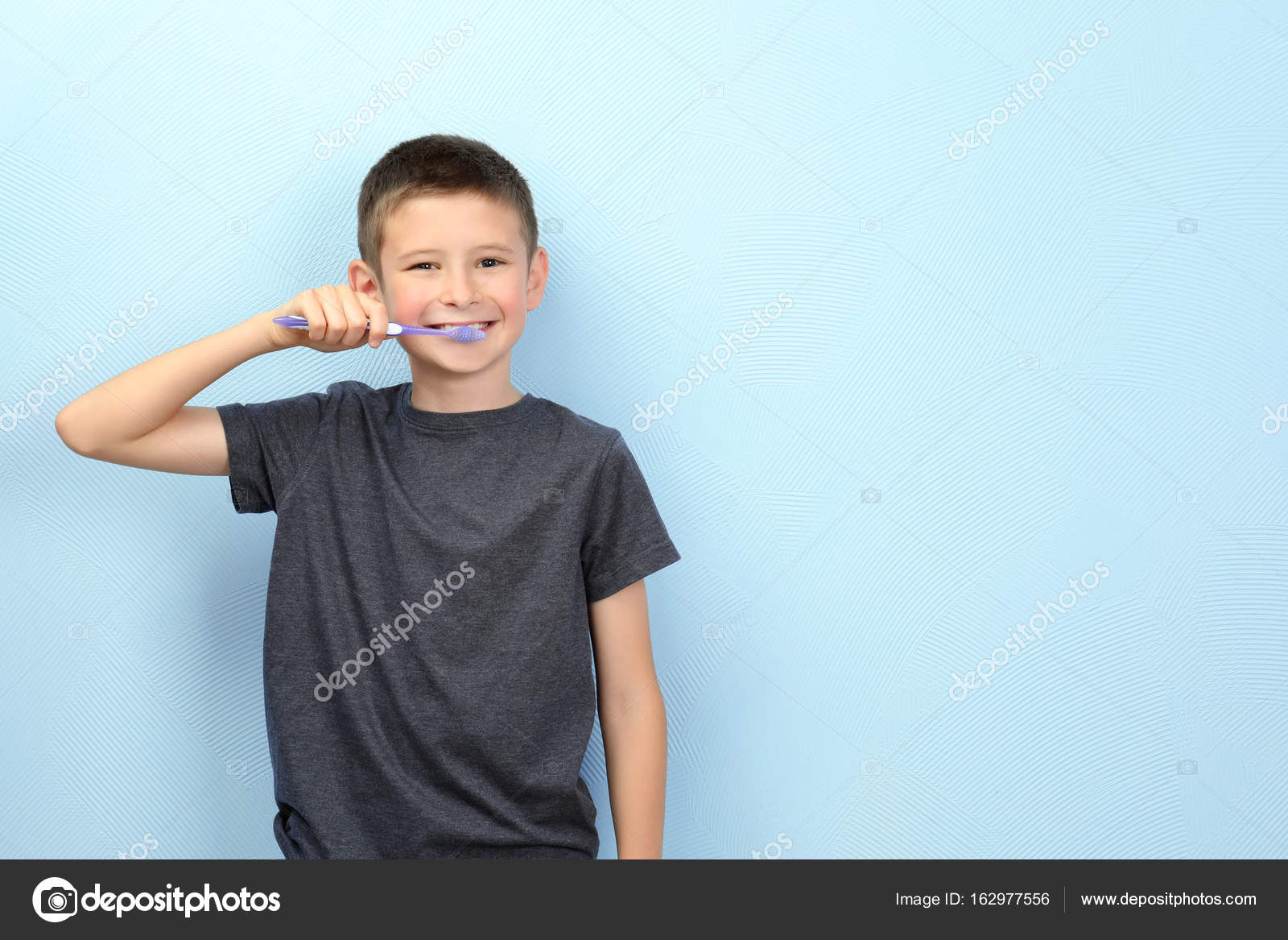 Cute little boy cleaning teeth on color background Stock Photo by ...