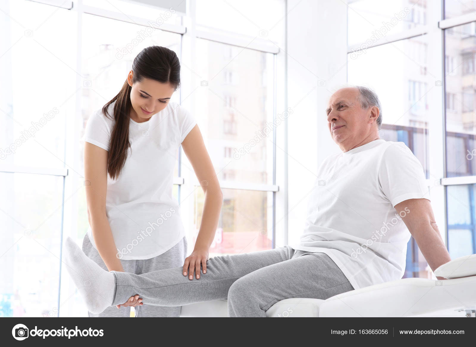 Physiotherapist working with elderly patient in clinic Stock Photo by ...
