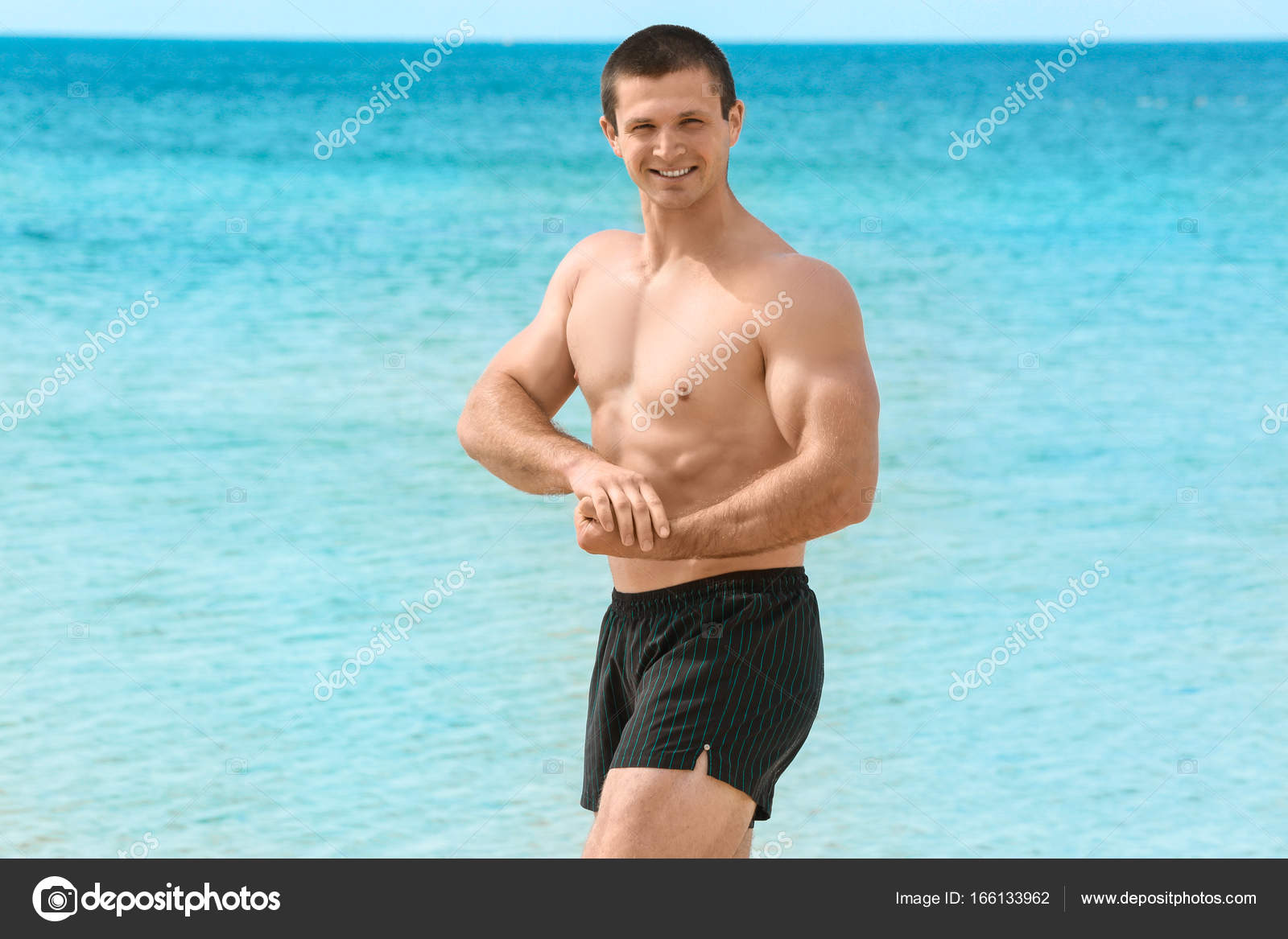 Handsome young man on sea beach — Stock Photo © belchonock #166133962