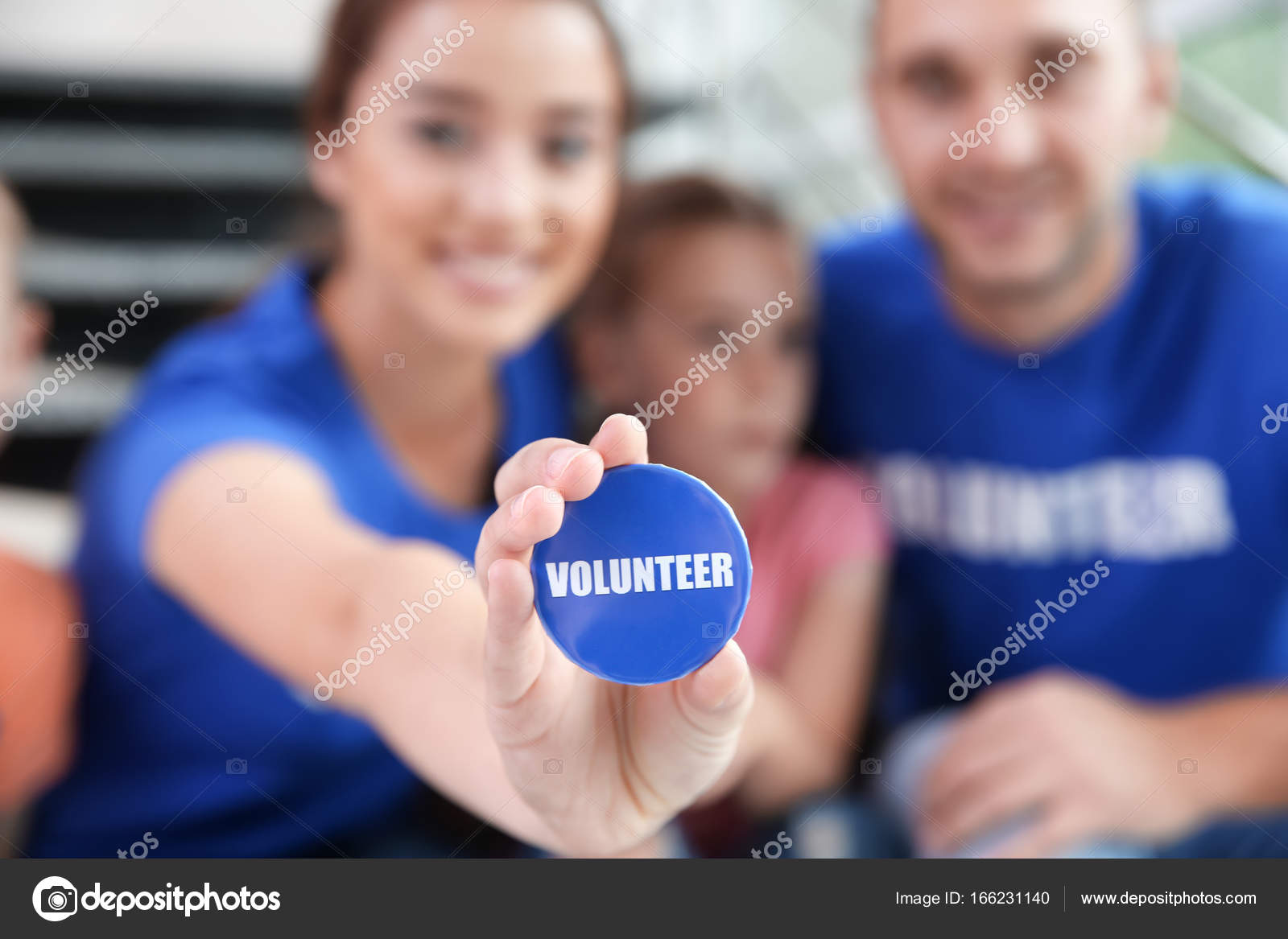 Volunteer button in young woman's hand indoors — Stock Photo © belchonock #166231140