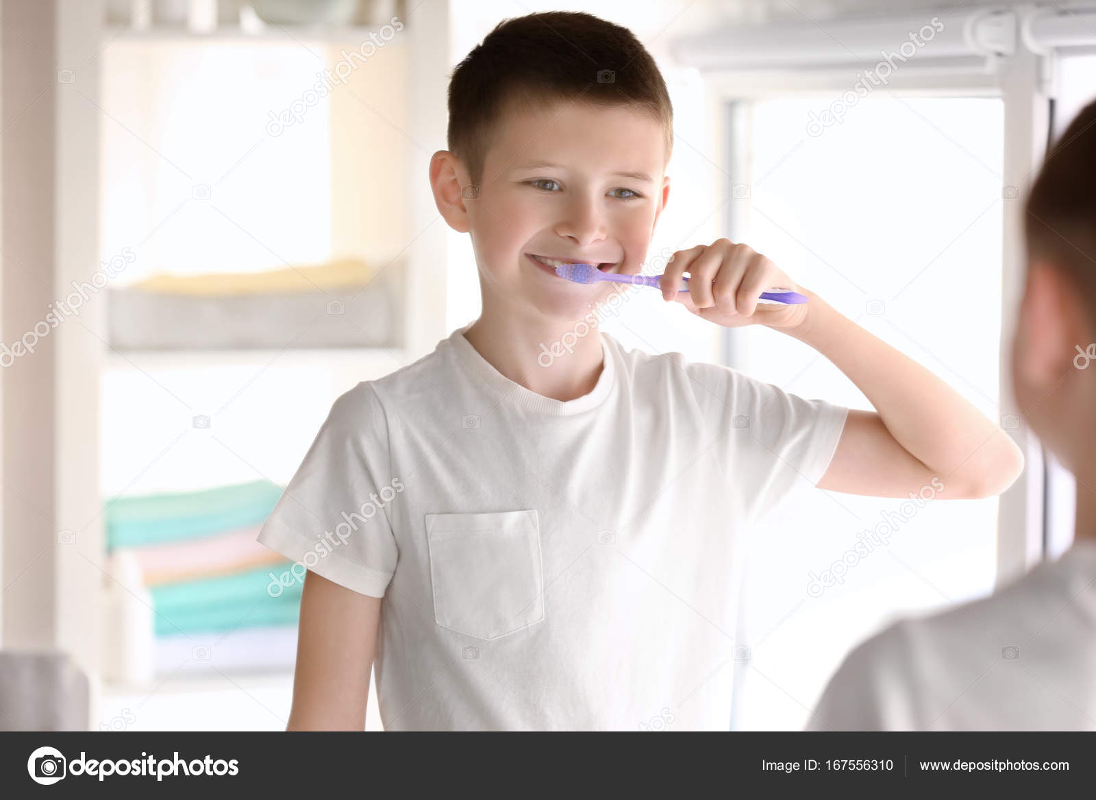 Cute little boy cleaning teeth at home Stock Photo by ©belchonock 167556310
