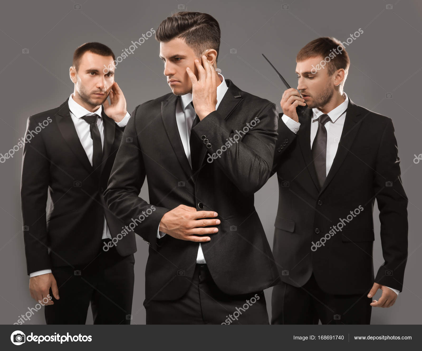 Handsome bodyguards on grey background Stock Photo by ©belchonock 168691740