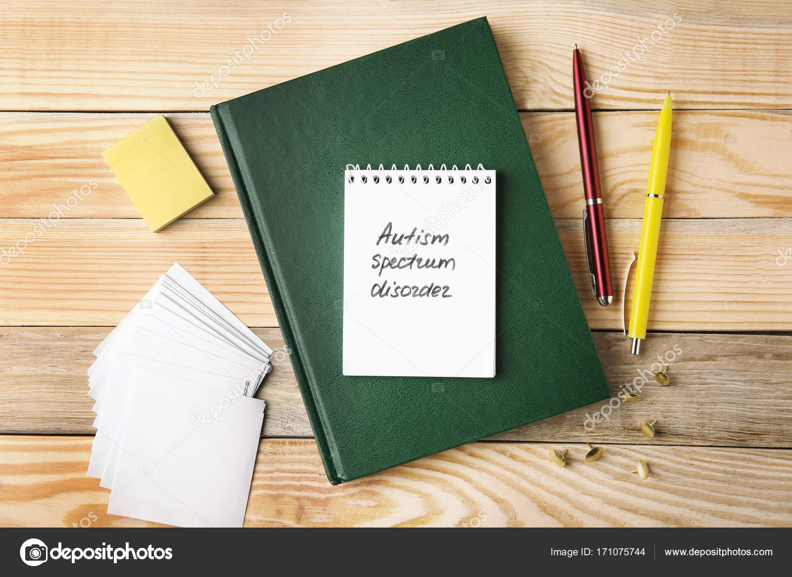 Notepad with text AUTISM SPECTRUM DISORDER and stationery on wooden ...
