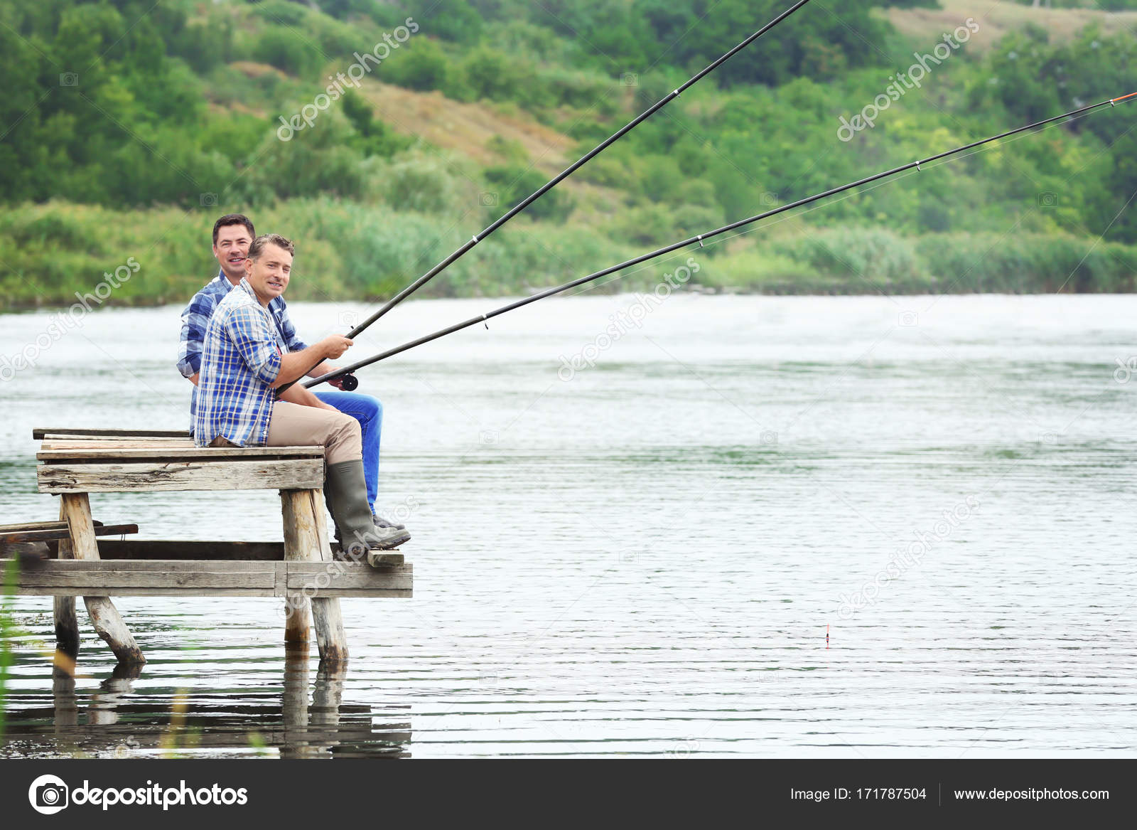 Dos hombres pescando desde el muelle en el río — Foto de stock ...