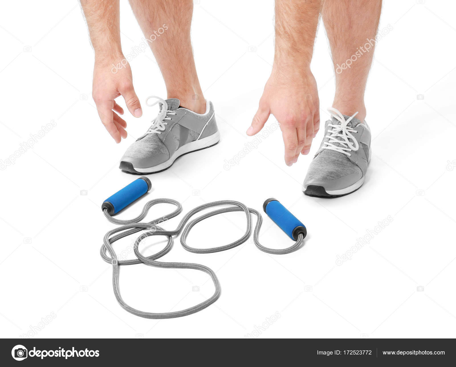 Young man reaching for jumping rope Stock Photo by ©belchonock 172523772