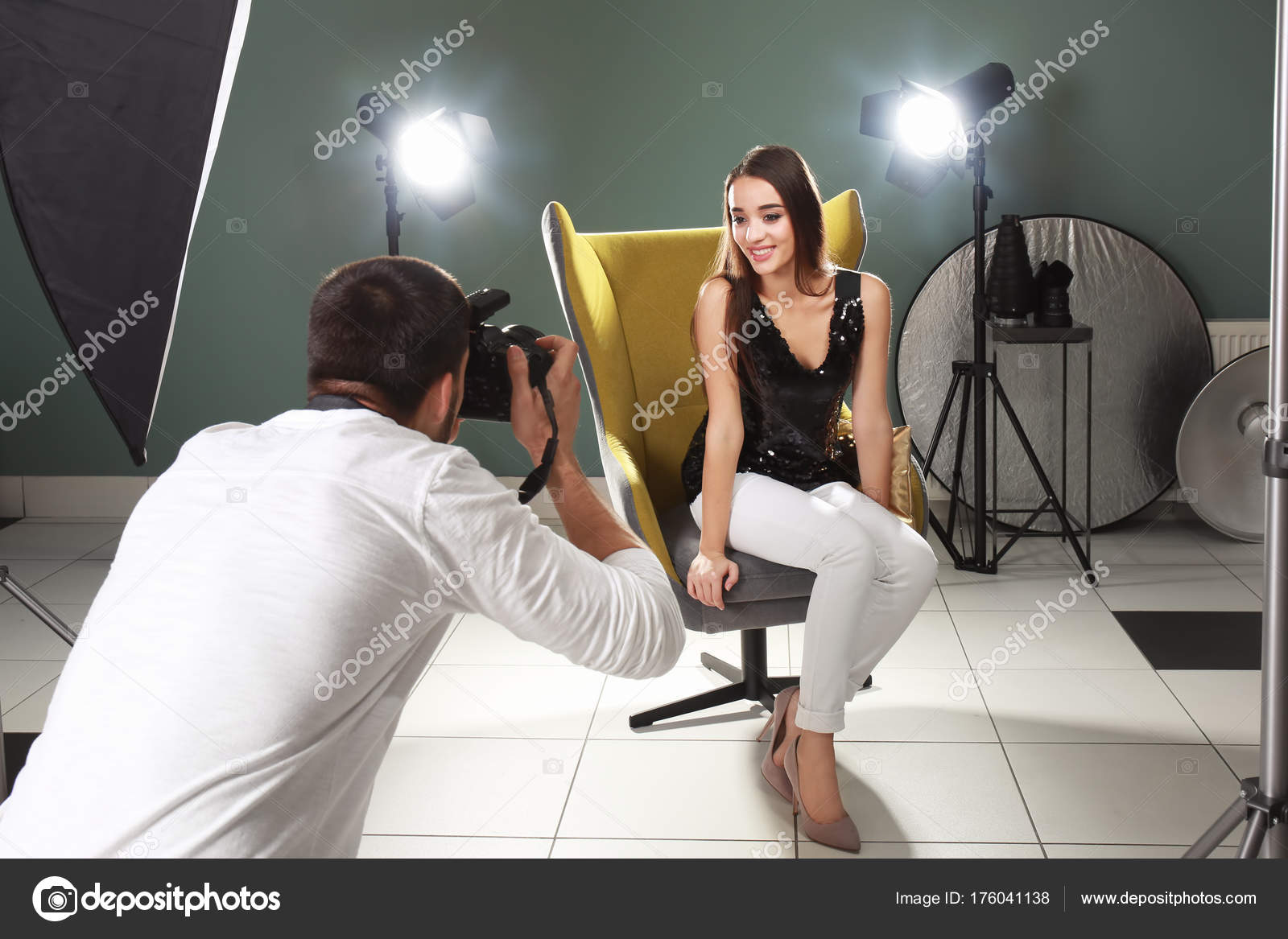 Beautiful young model posing for professional photographer in studio ...