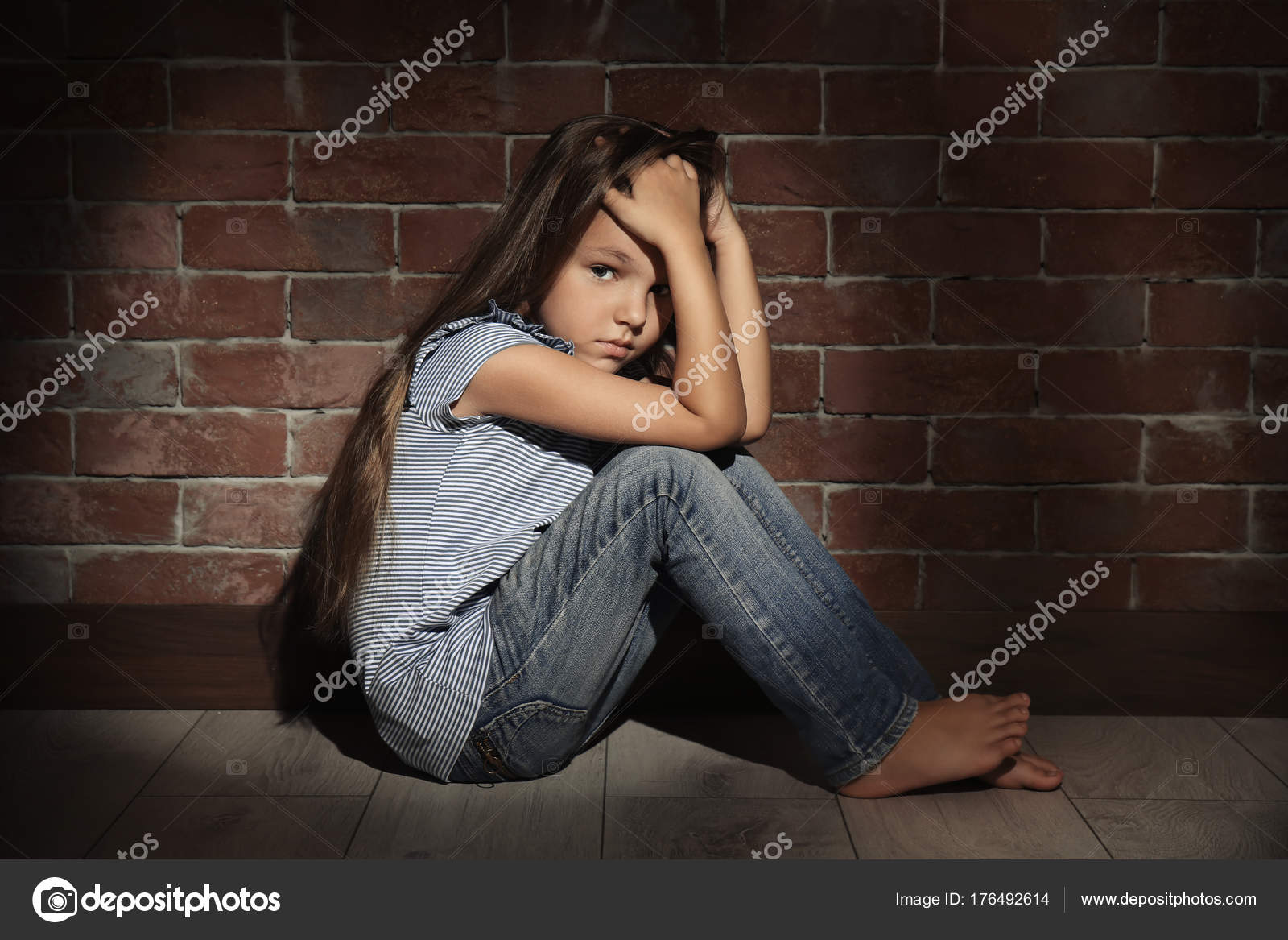 Sad Girl Sitting Against Wall