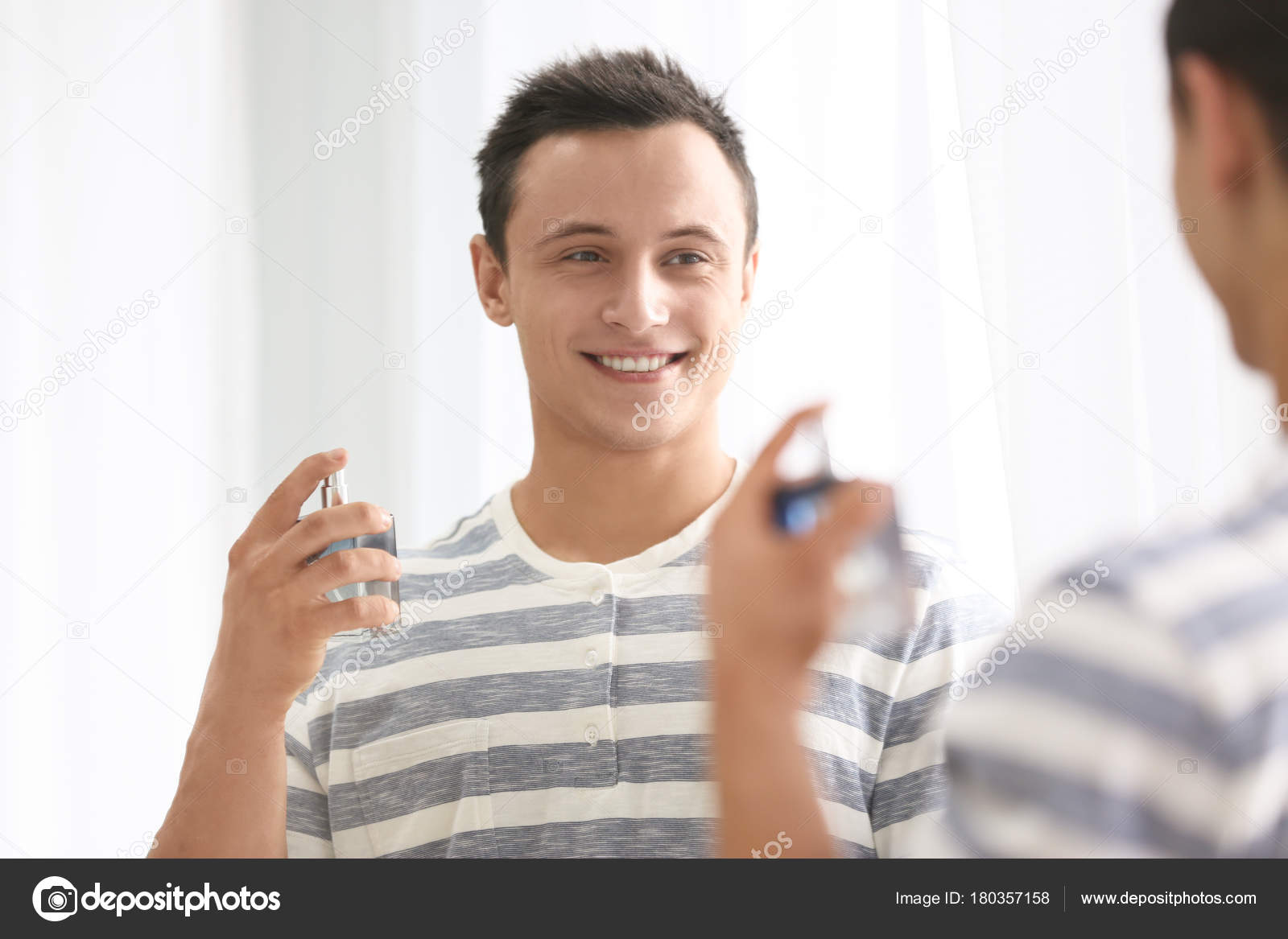 Handsome young man using perfume at home Stock Photo by ©belchonock ...