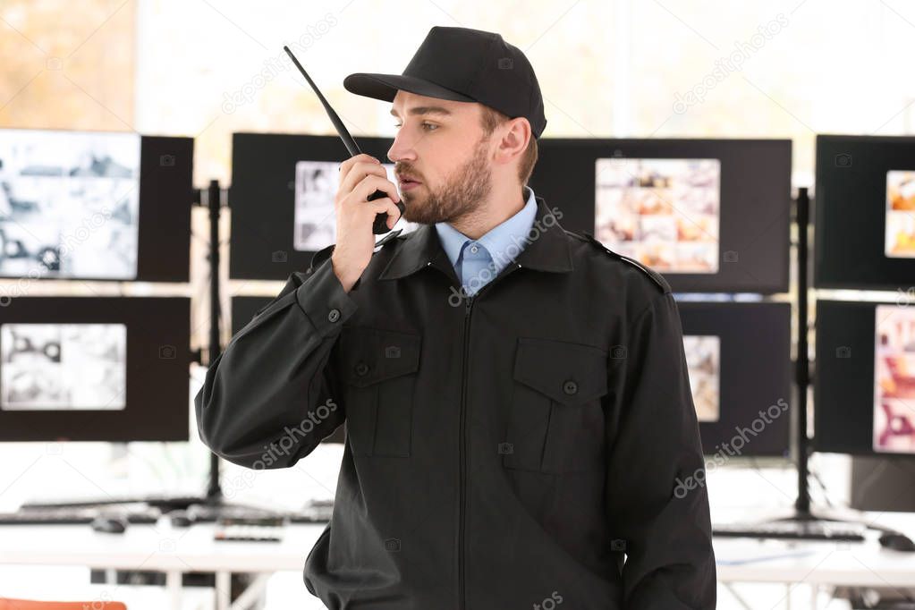 Guardia de seguridad masculino usando transmisor de radio en la sala de ...