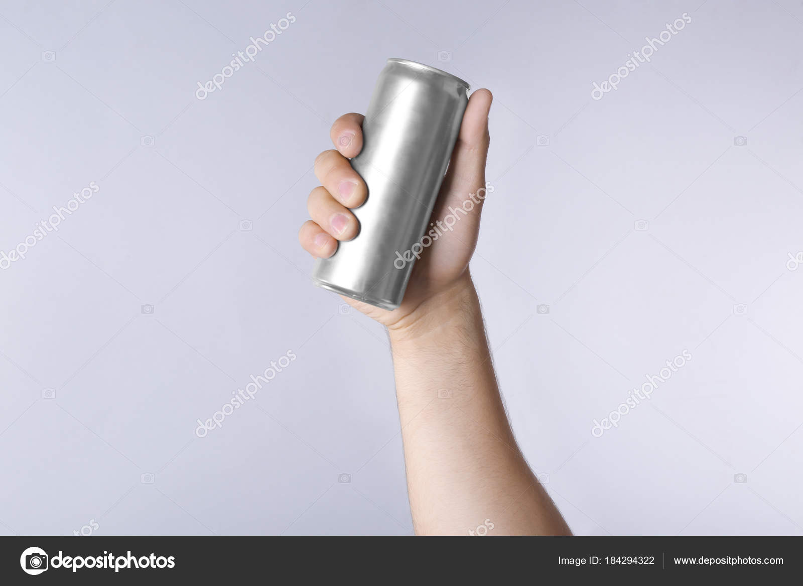 Male hand with aluminum can on light background Stock Photo by ...