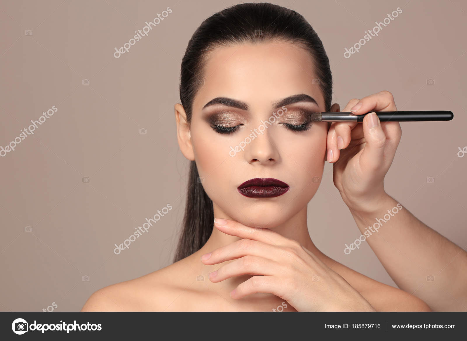 Professional visage artist applying makeup on woman's face against ...