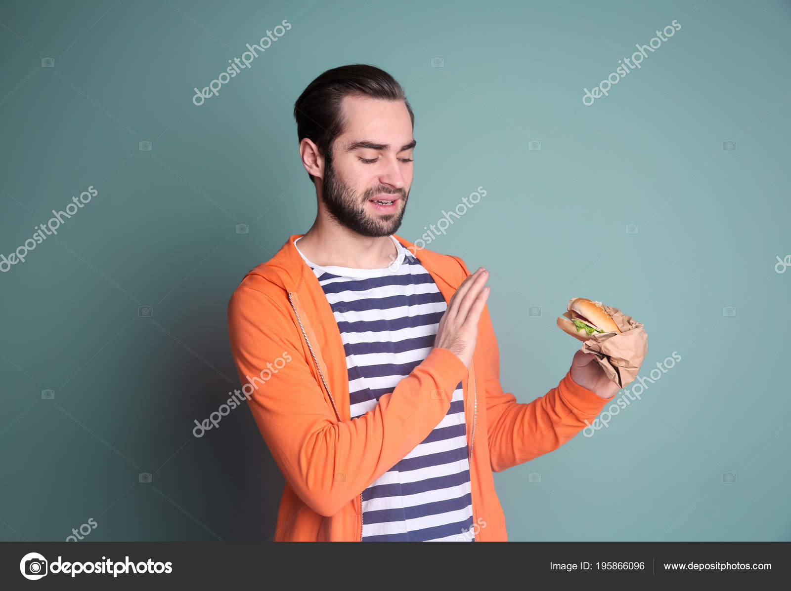 Handsome man refusing unhealthy burger Stock Photo by ©belchonock 195866096