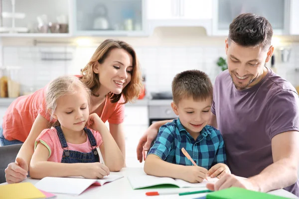 Children with parents doing homework — Stock Photo © belchonock #195865906