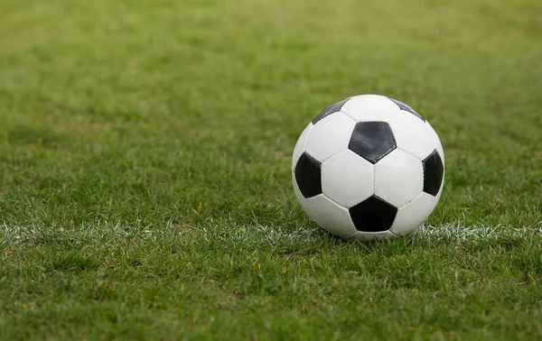 Bola de f tbol cl sica, patr n t pico blanco y negro, colocada en la l nea de marcado blanco del ...