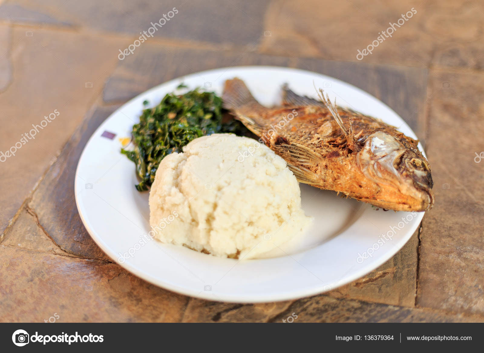 Traditional african food - ugali, fish and greens Stock Photo by ...