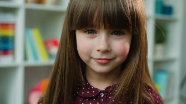 Face portrait of cute little girl looking at the camera and smiling ...