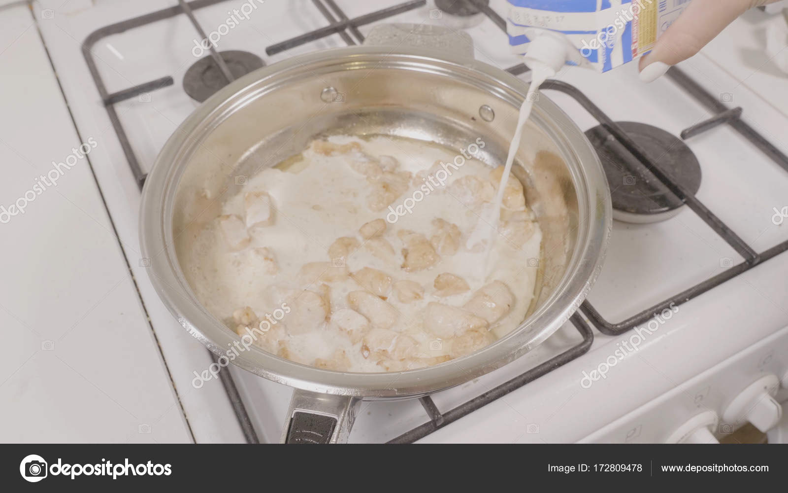 Top view of adding milk to the pan with the chicken. Closeup of chicken ...
