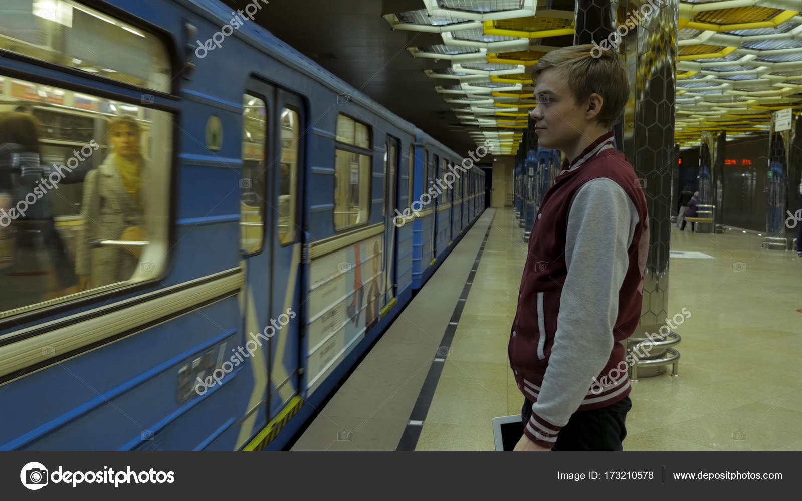 Man using touchpad or smartphone when he waits for train at subway ...