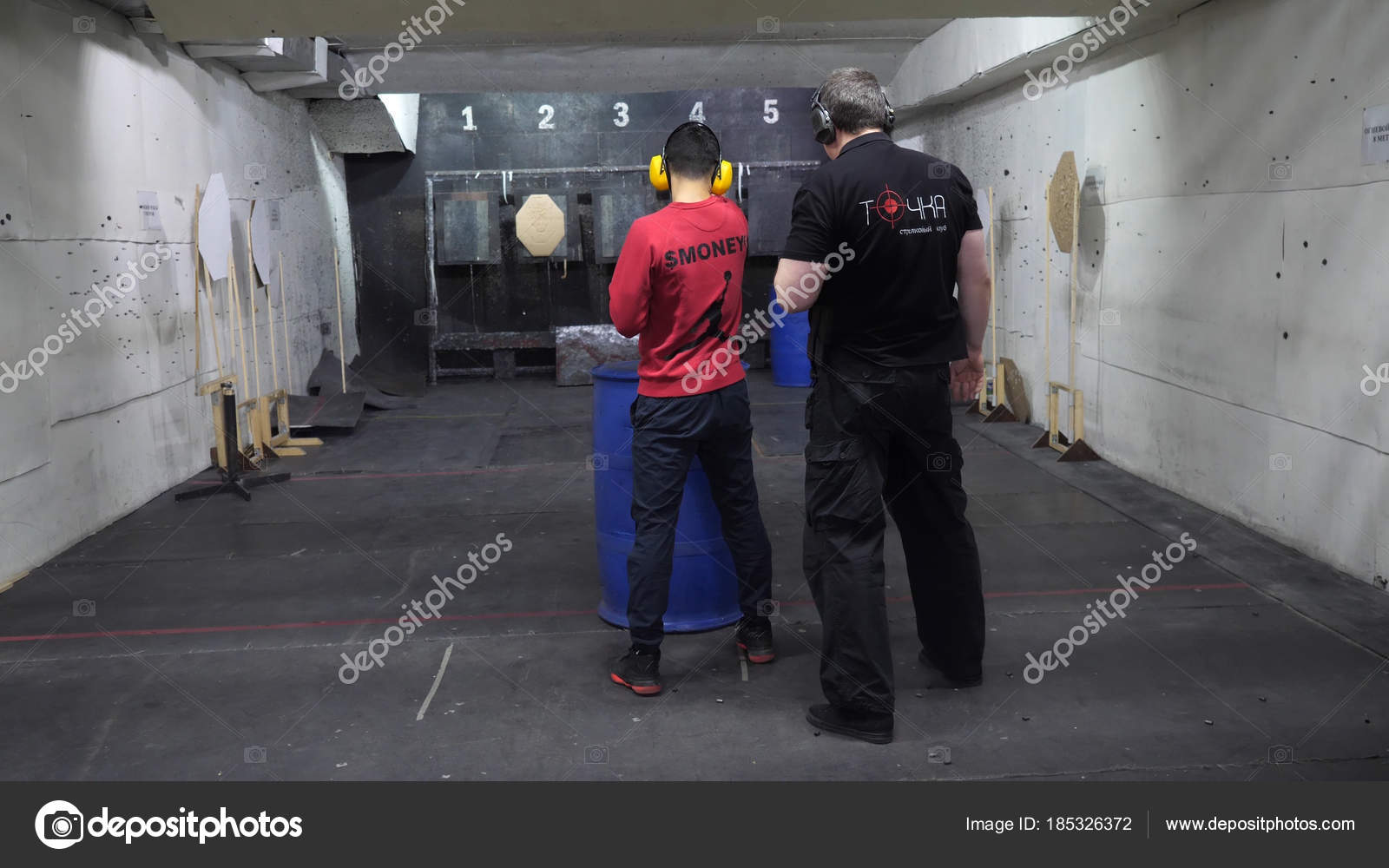 Man shoots at the shooting range with the instructor. Man trains ...