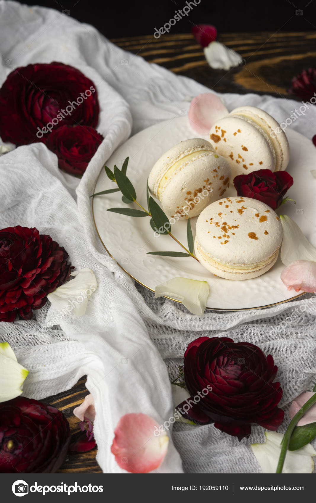 Three macaroons pastry lying on a plate surrounded by rose bloss Stock ...