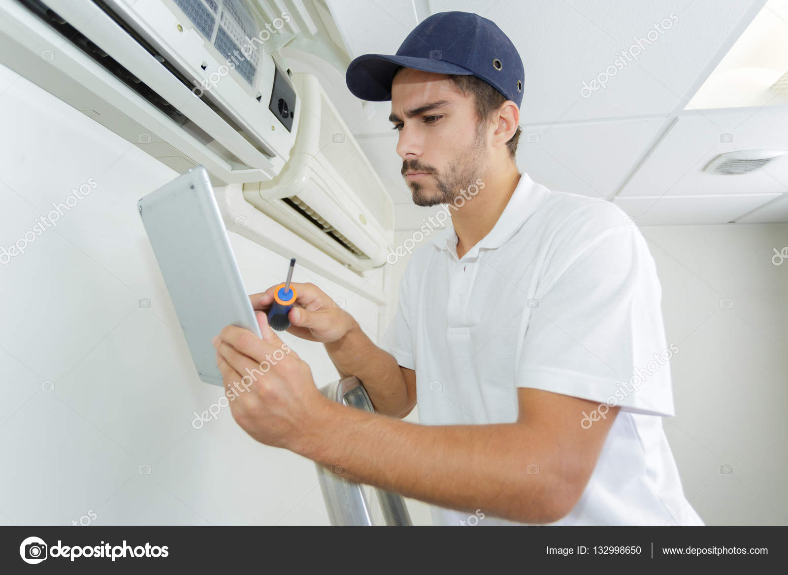 Young contractor working carefully and seriously at clients office ...