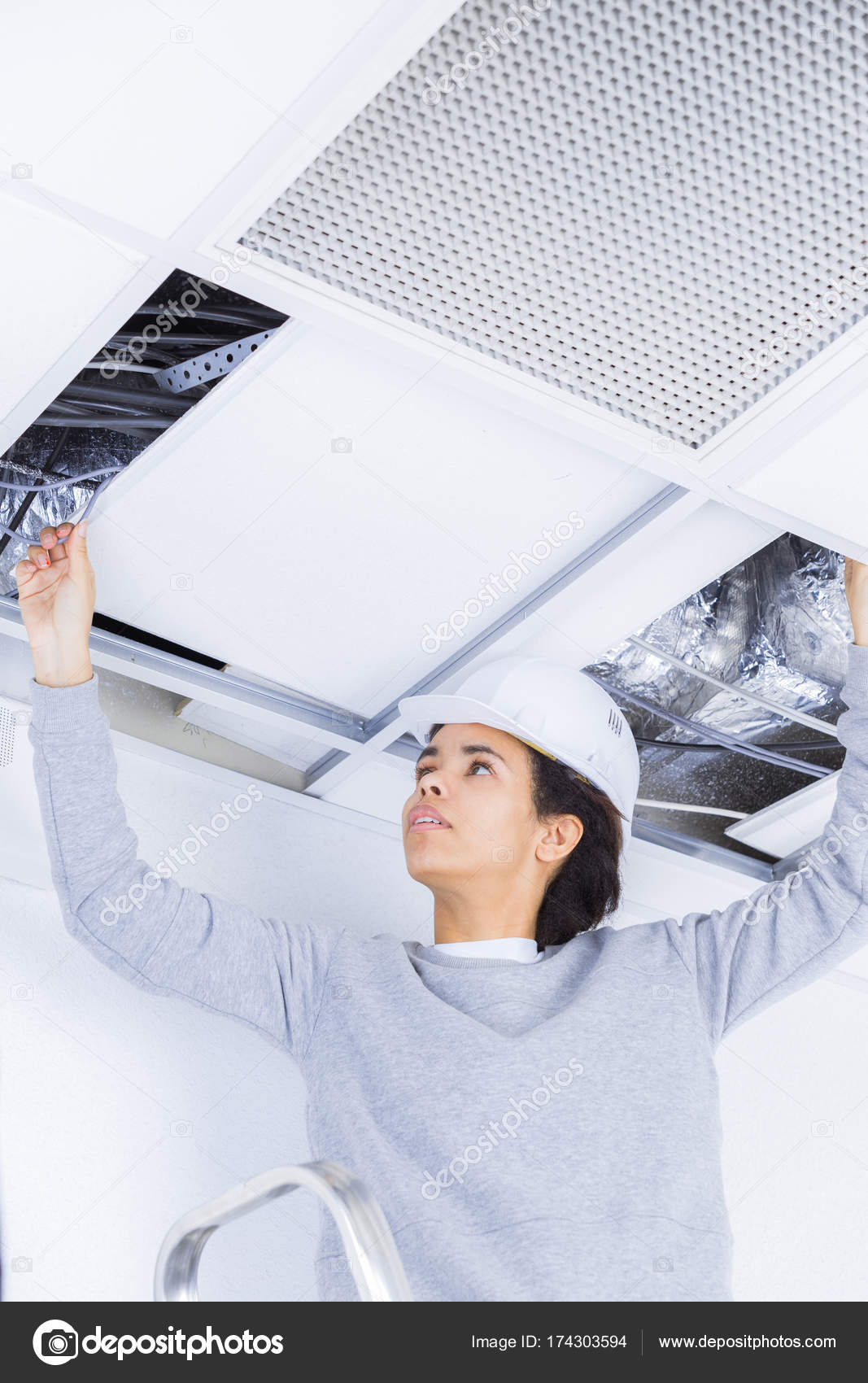 Contractor reaching overhead into roof space Stock Photo by ...