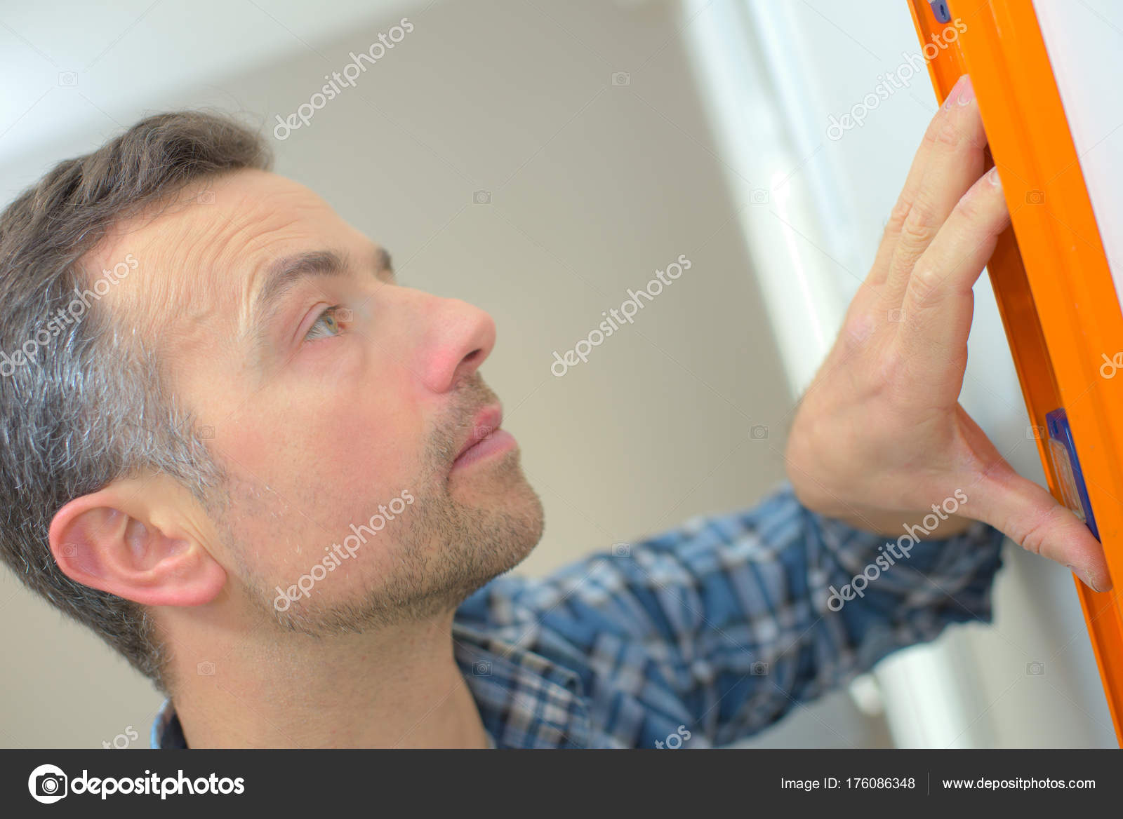 Man using spirit level on white wall at home Stock Photo by ...