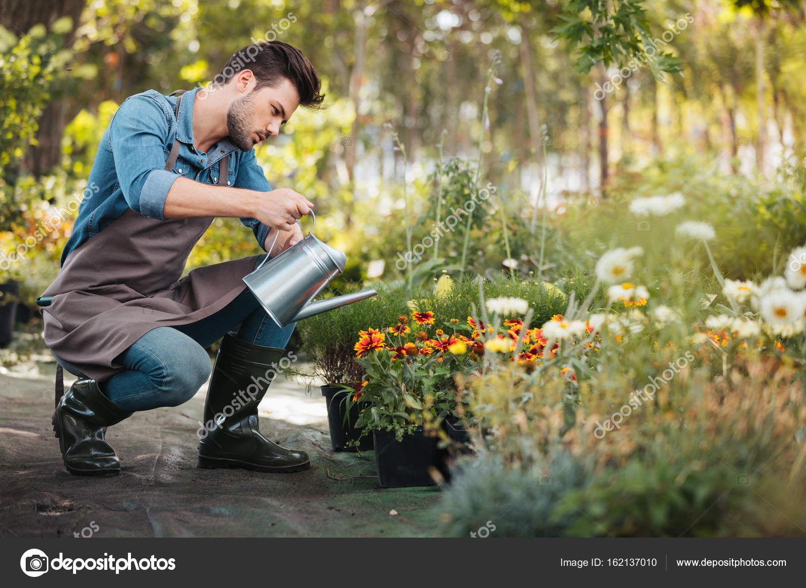 Gardener watering plants — Stock Photo © SashaKhalabuzar #162137010