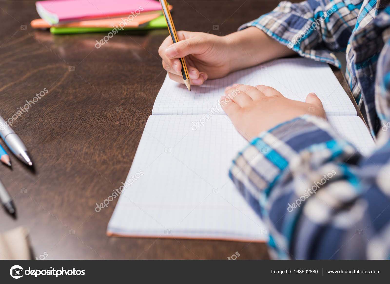Kid writing in notebook Stock Photo by ©AlexLipa 163602880