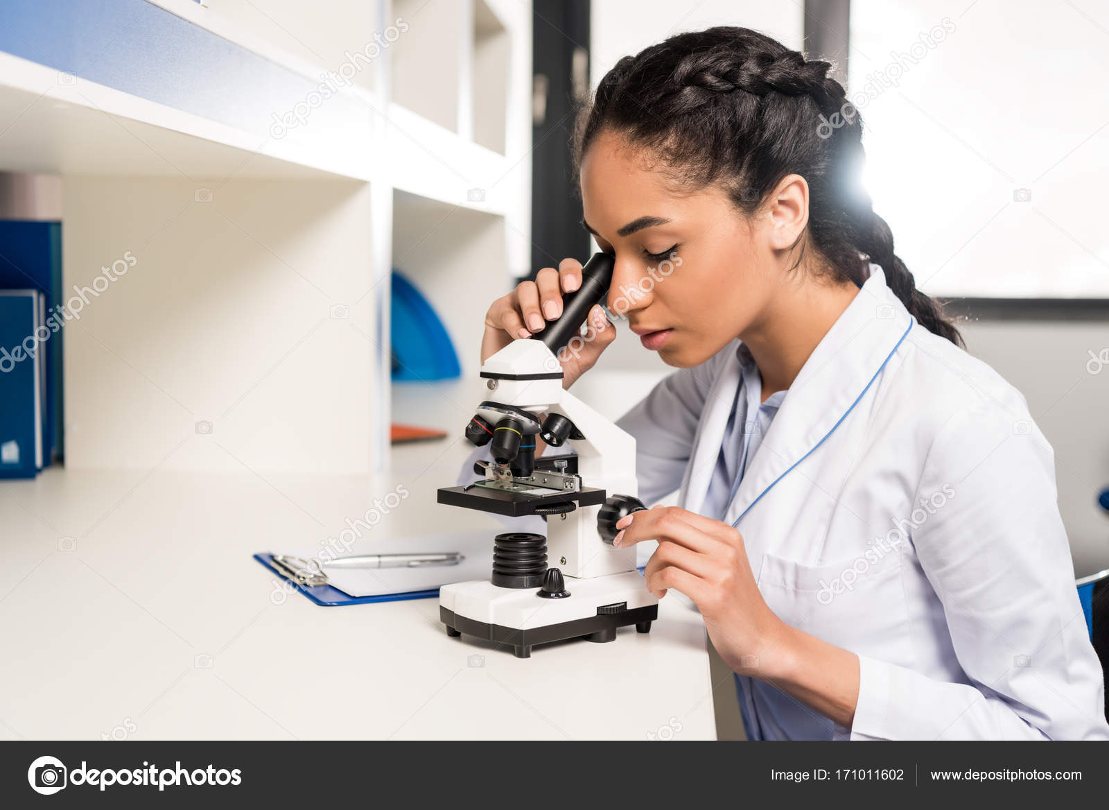 Laboratory technician using microscope Stock Photo by ©AlexLipa 171011602