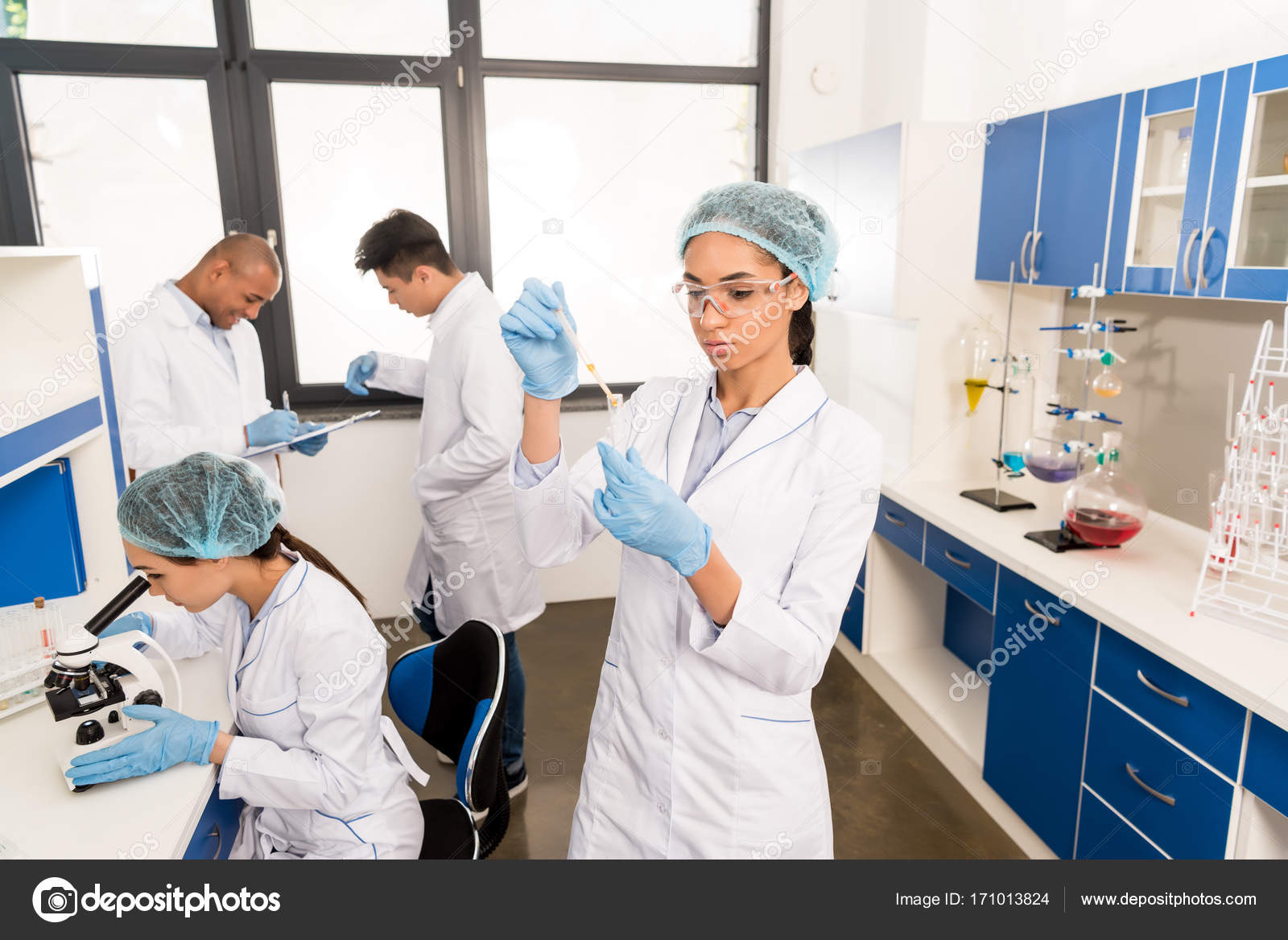 Scientist pouring liquid into test tube Stock Photo by ©AlexLipa 171013824