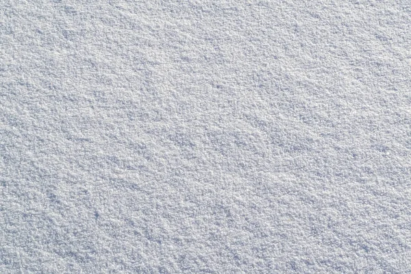 The texture of pure white snow. Close up of fresh clean snow with blue ...
