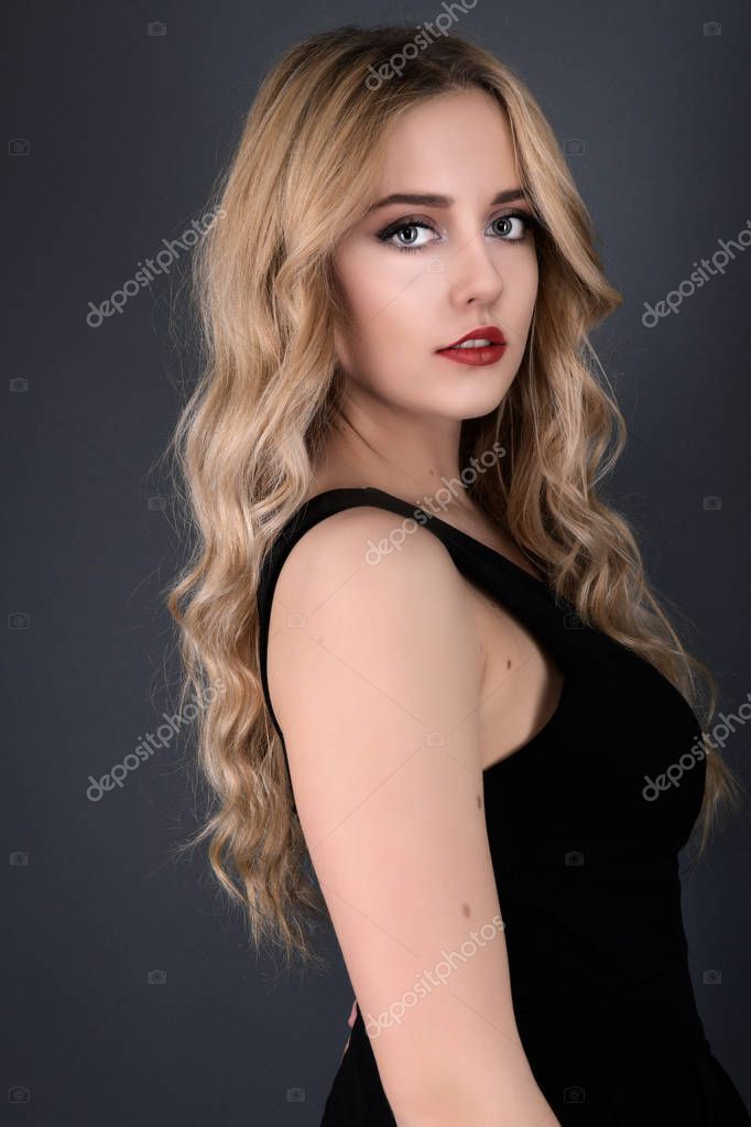 Chica rubia con el pelo ondulado largo y brillante volumen. Hermosa modelo de mujer con peinado ...